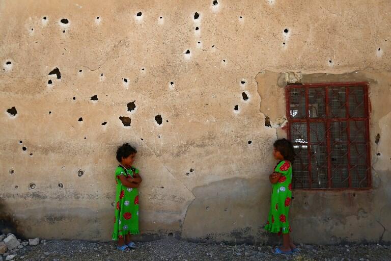 Syrian girls pose for a photograph against a bullet-riddled wall | Al ...